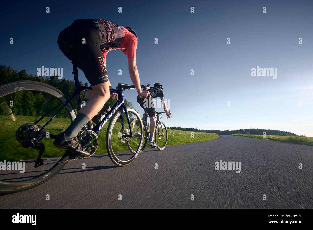Two young men on racing bikes Stock Photo - Alamy