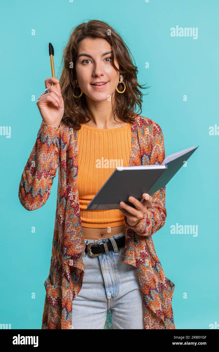 Thoughtful journalist woman making notes, writing down thoughts with ...
