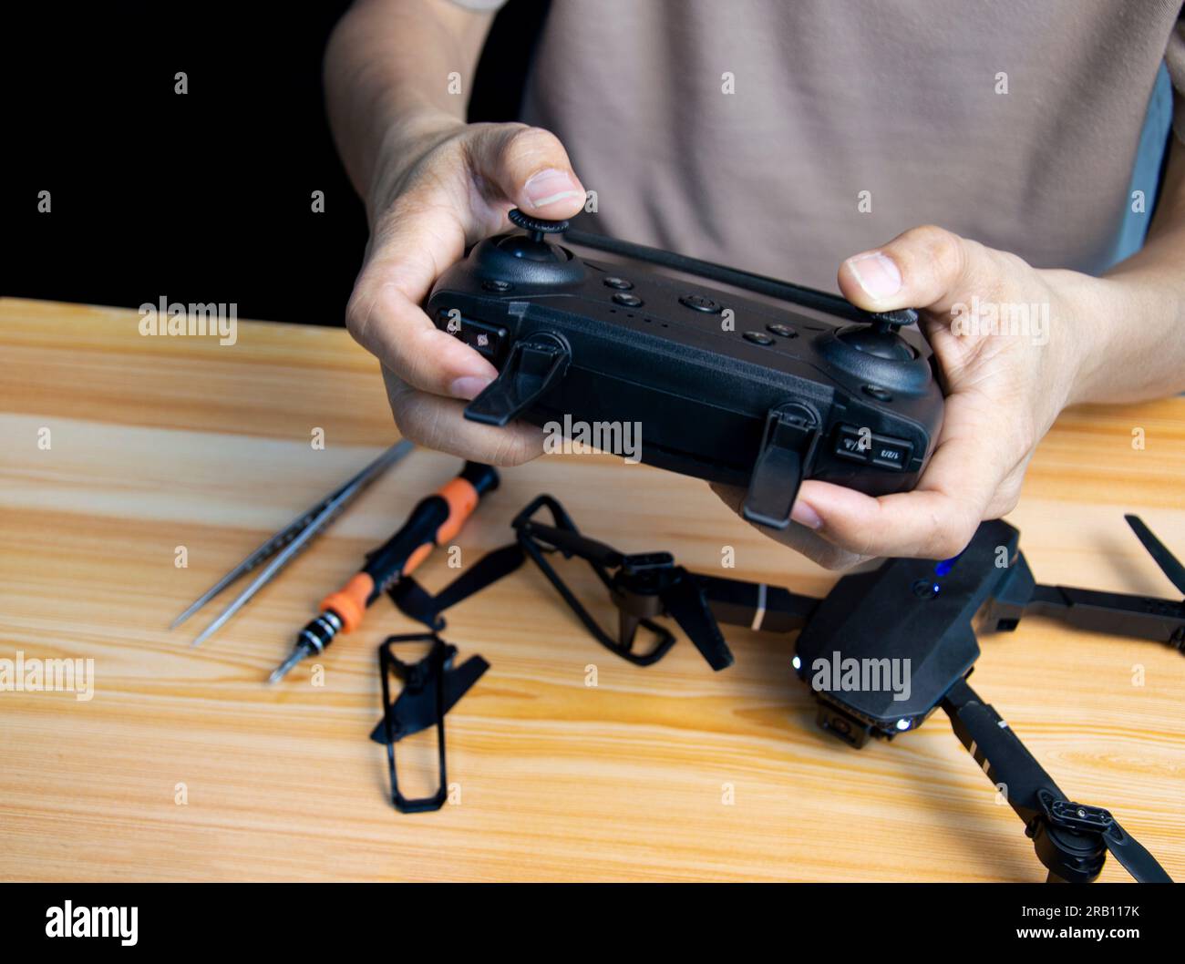 Professional mechanic repairing a drone, setting it up, on a table with ...