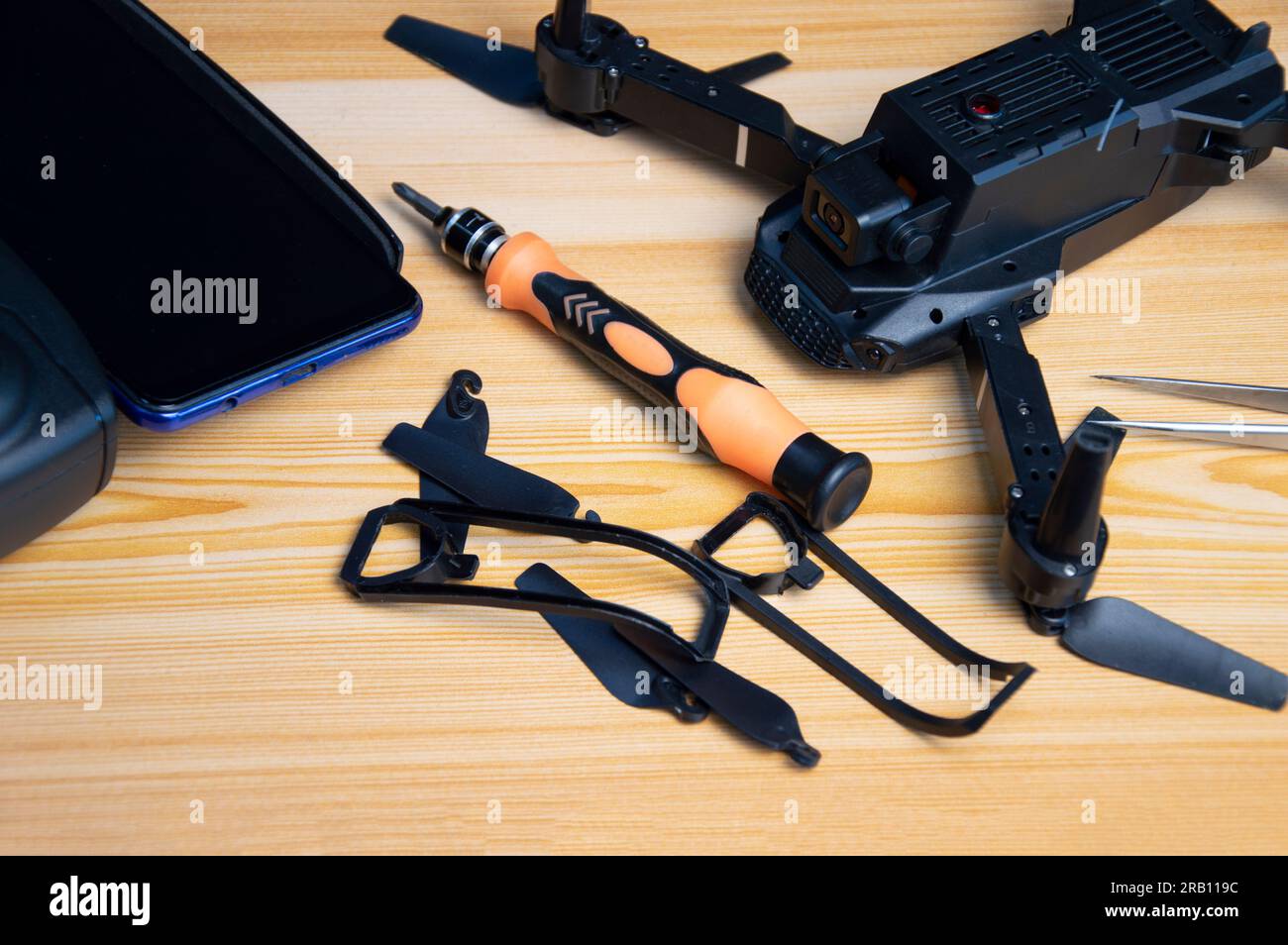 Repairing a small screwdriver drone on the table with various tools in ...