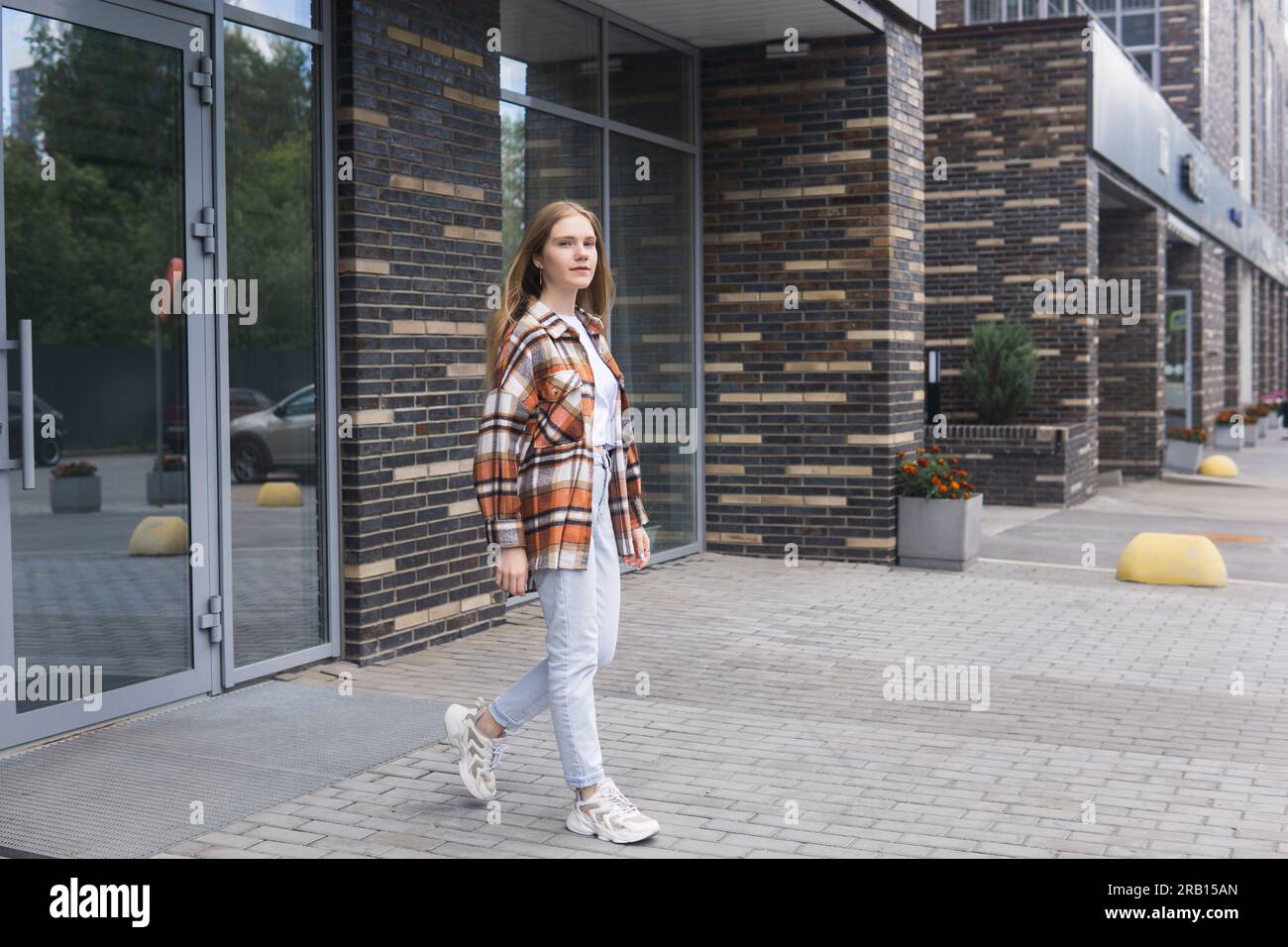 young woman stepped out of the door of a city building Stock Photo - Alamy