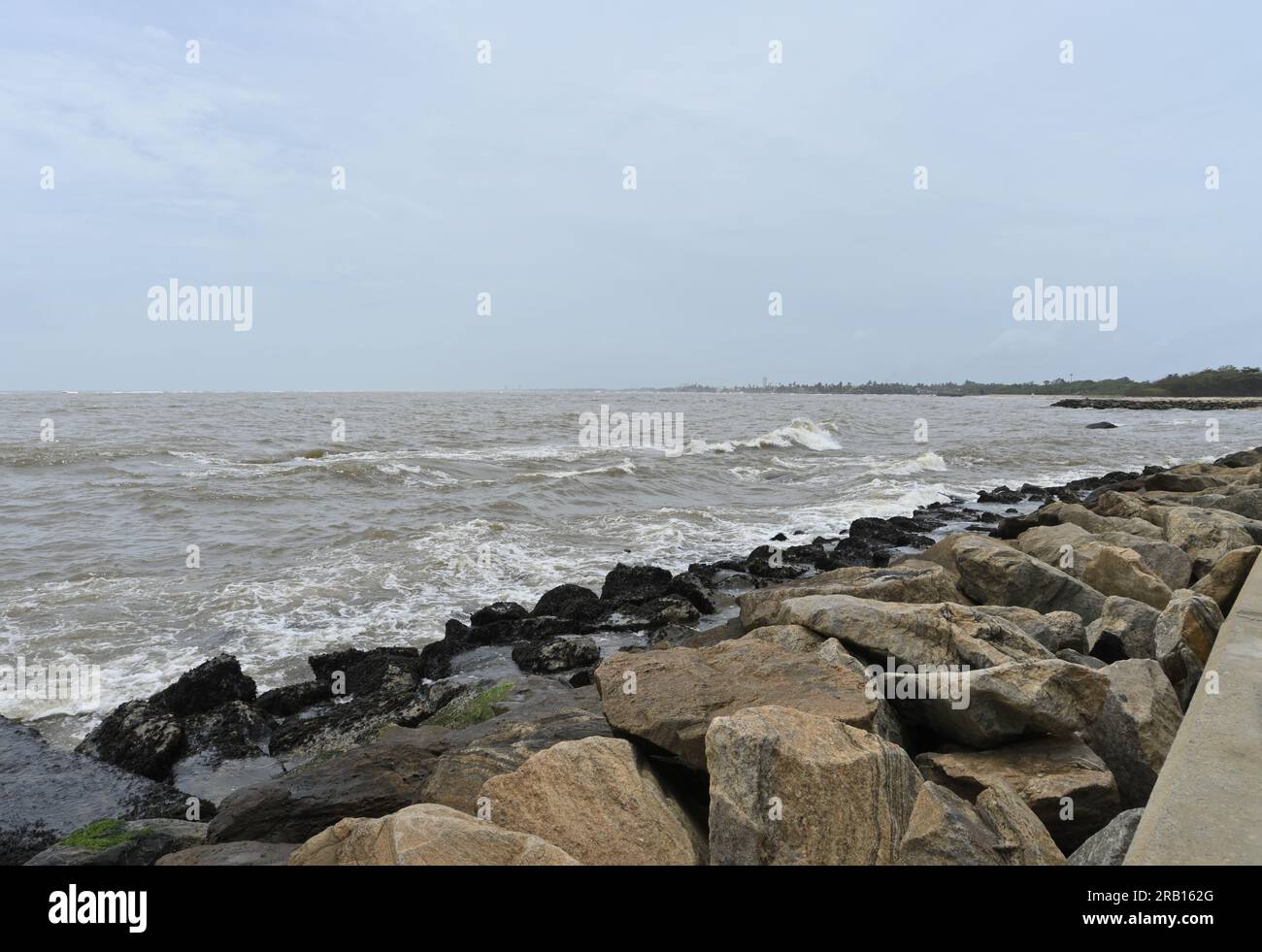 Angle view of the granite rock dam on the shoreline and the ocean tides ...
