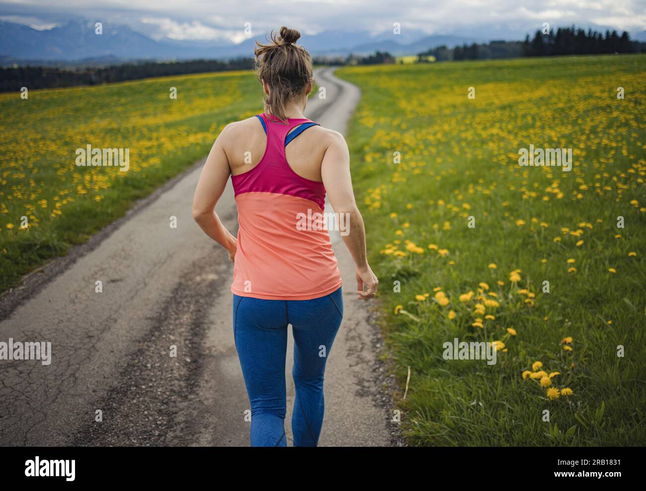 Woman running along road hi-res stock photography and images - Alamy