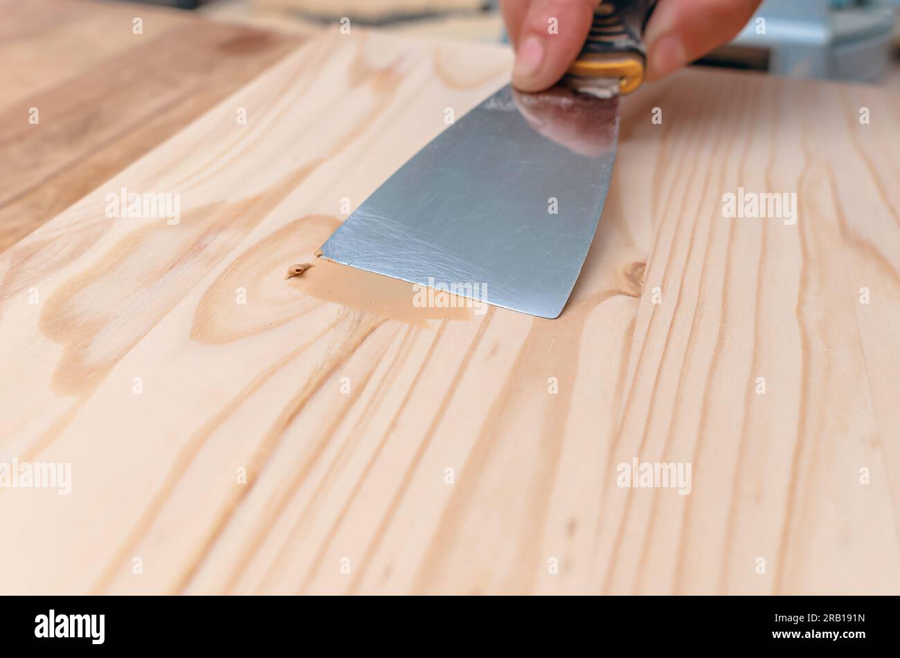 Process of puttying wooden board. Spatula, putty, wooden board ...
