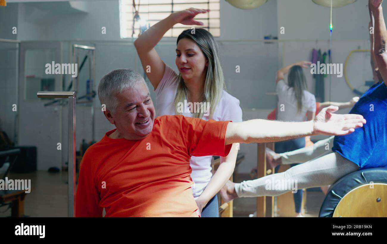 Pilates coach helping older man to stretch body, old age workout health ...