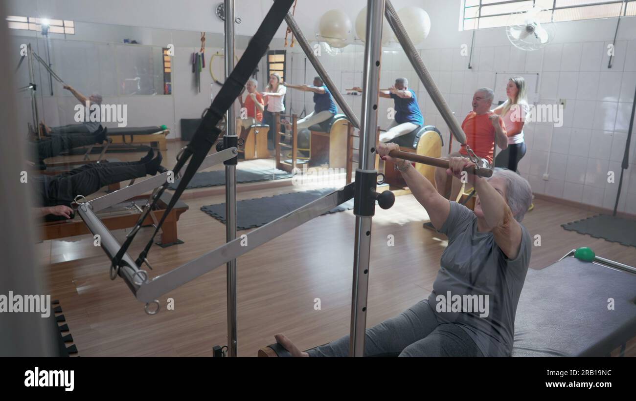 Pilates group session of elderly people exercising, candid authentic ...