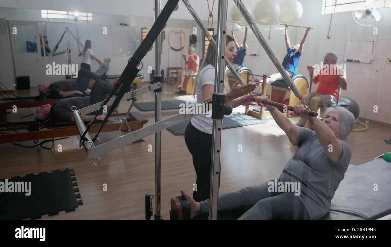 Pilates group session of elderly people exercising, candid authentic ...