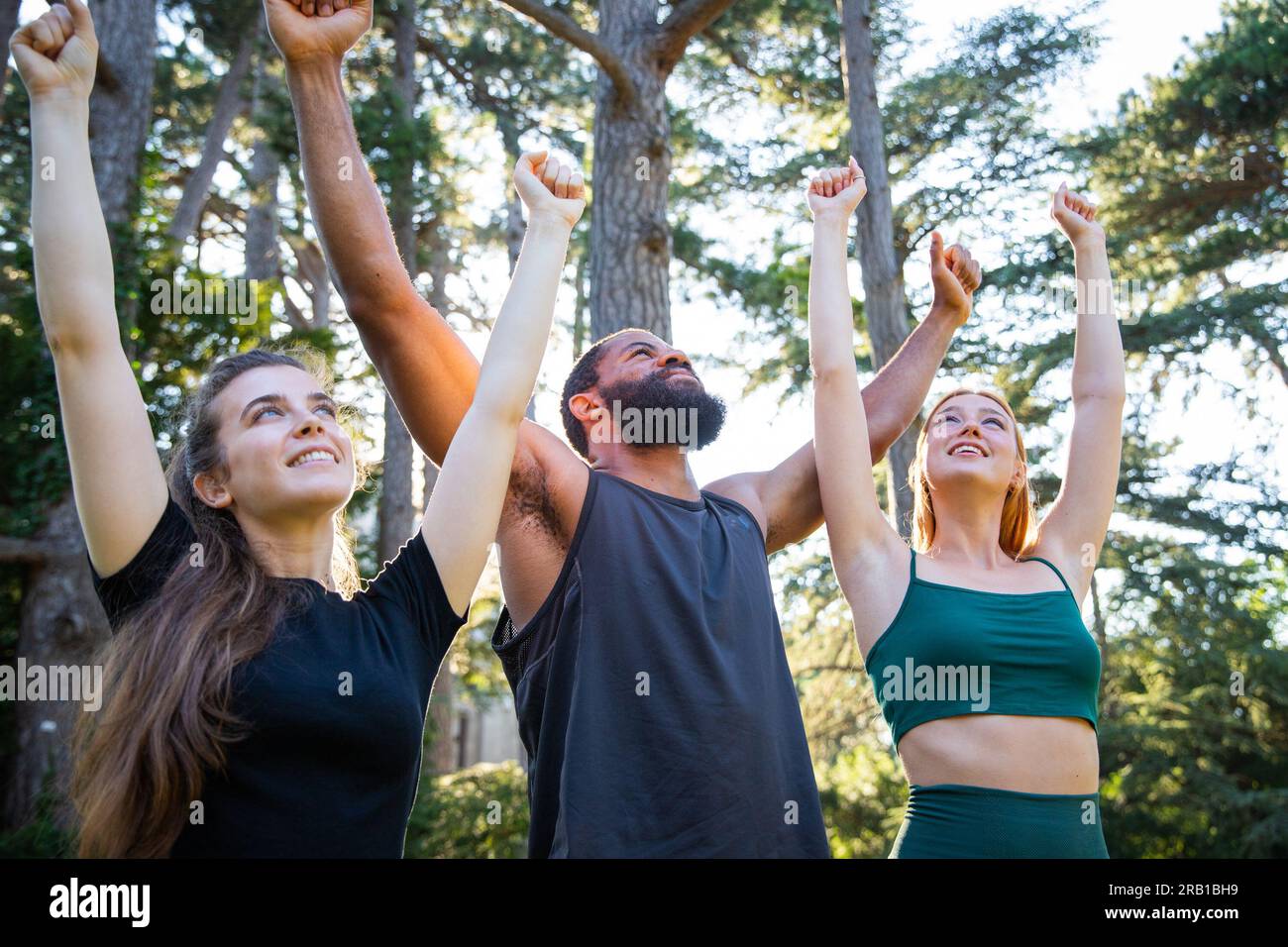 A group of sportspeople are happy with their hands raised in the air ...