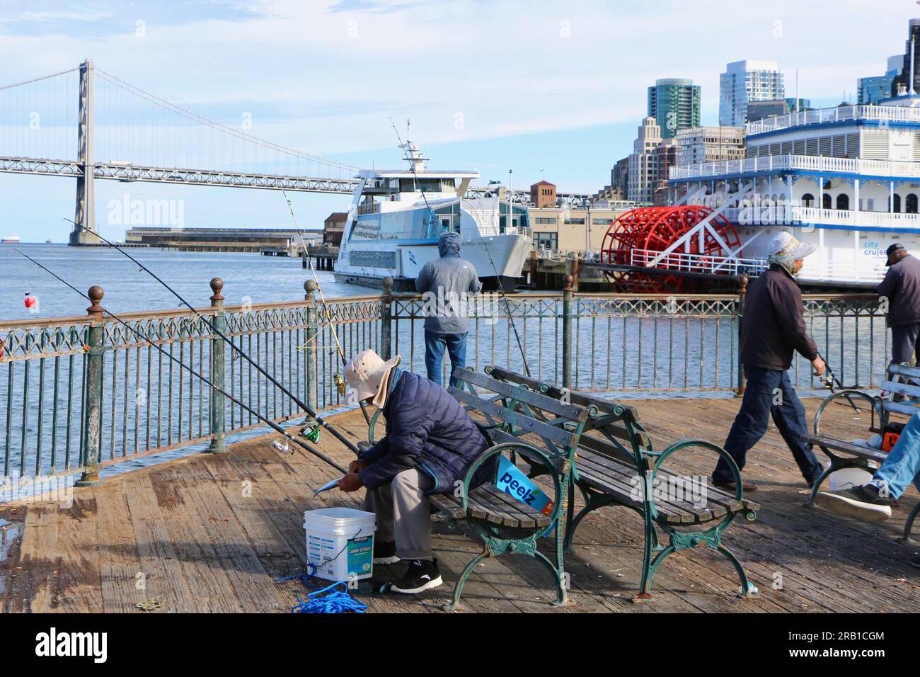 People rod and line fishing at the end of Pier 7 with Bay Bridge San ...