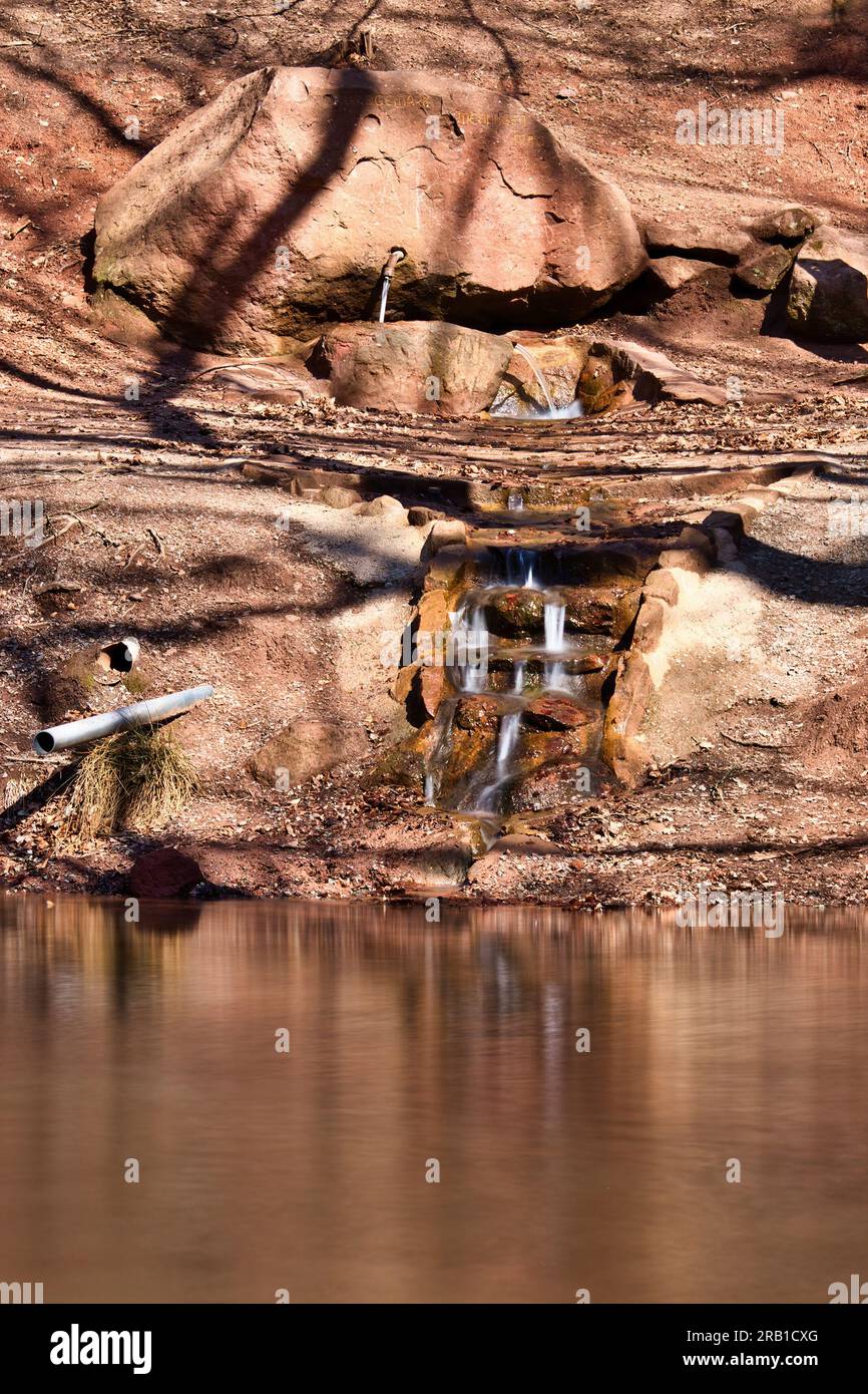 Water coming out of pipes over rocks into a lake in the Palatinate ...
