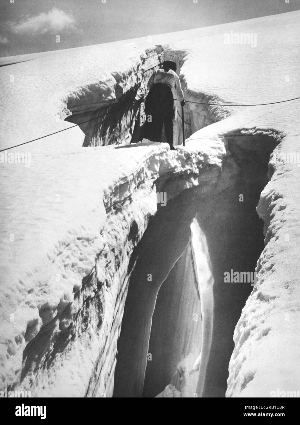 Switzerland: c. 1928 A mountain climber in the Swiss Alps cautiously ...