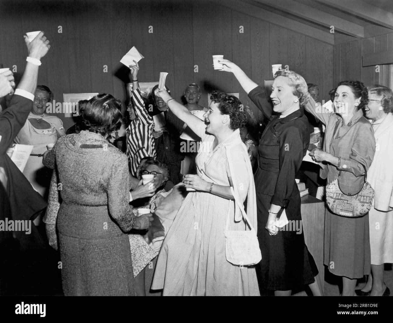 United States: c. 1955 A group of women at a gathering cheering and ...