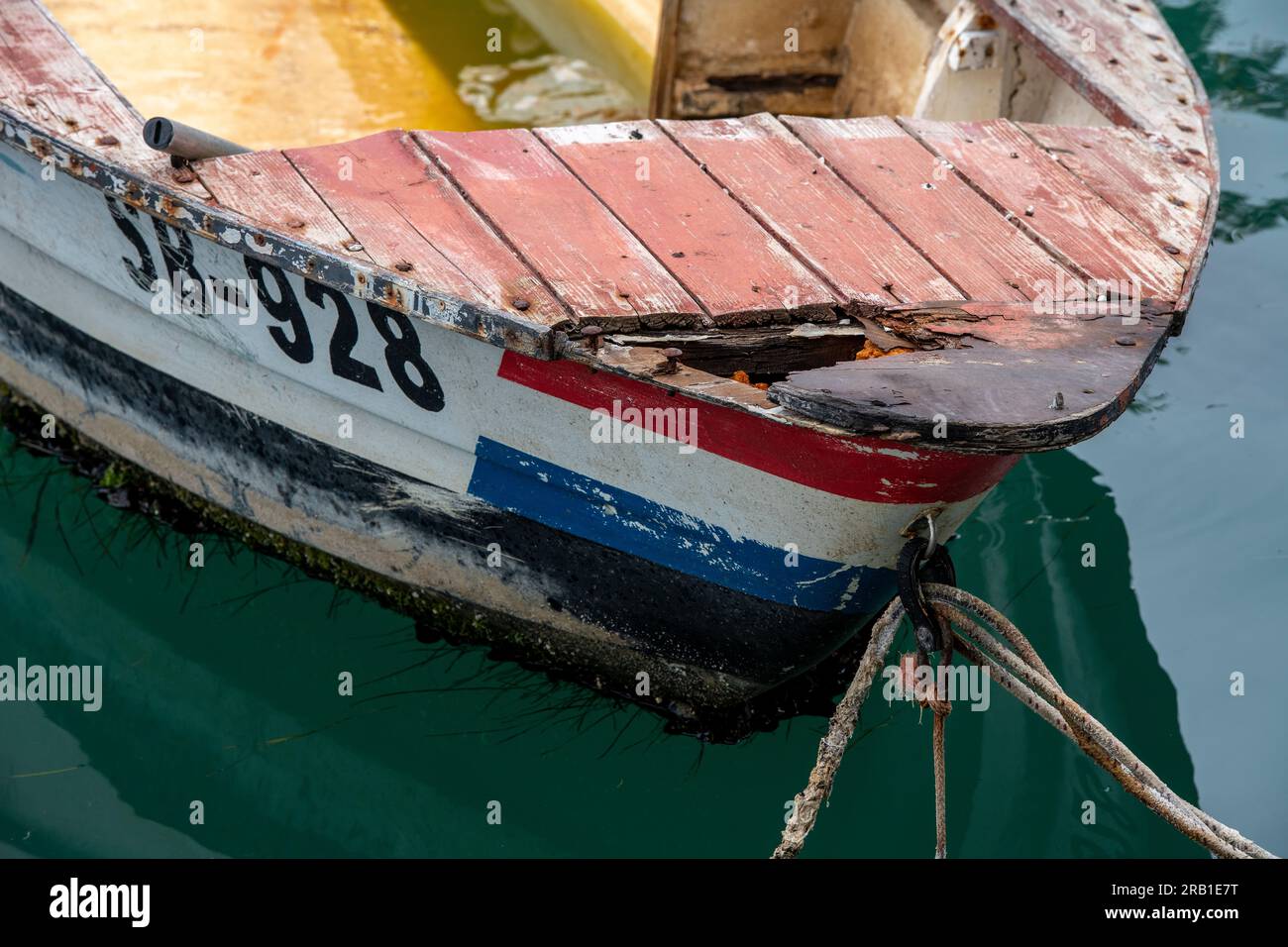 old wooden croatian fishing boat with flag painted on bows, old rotting ...
