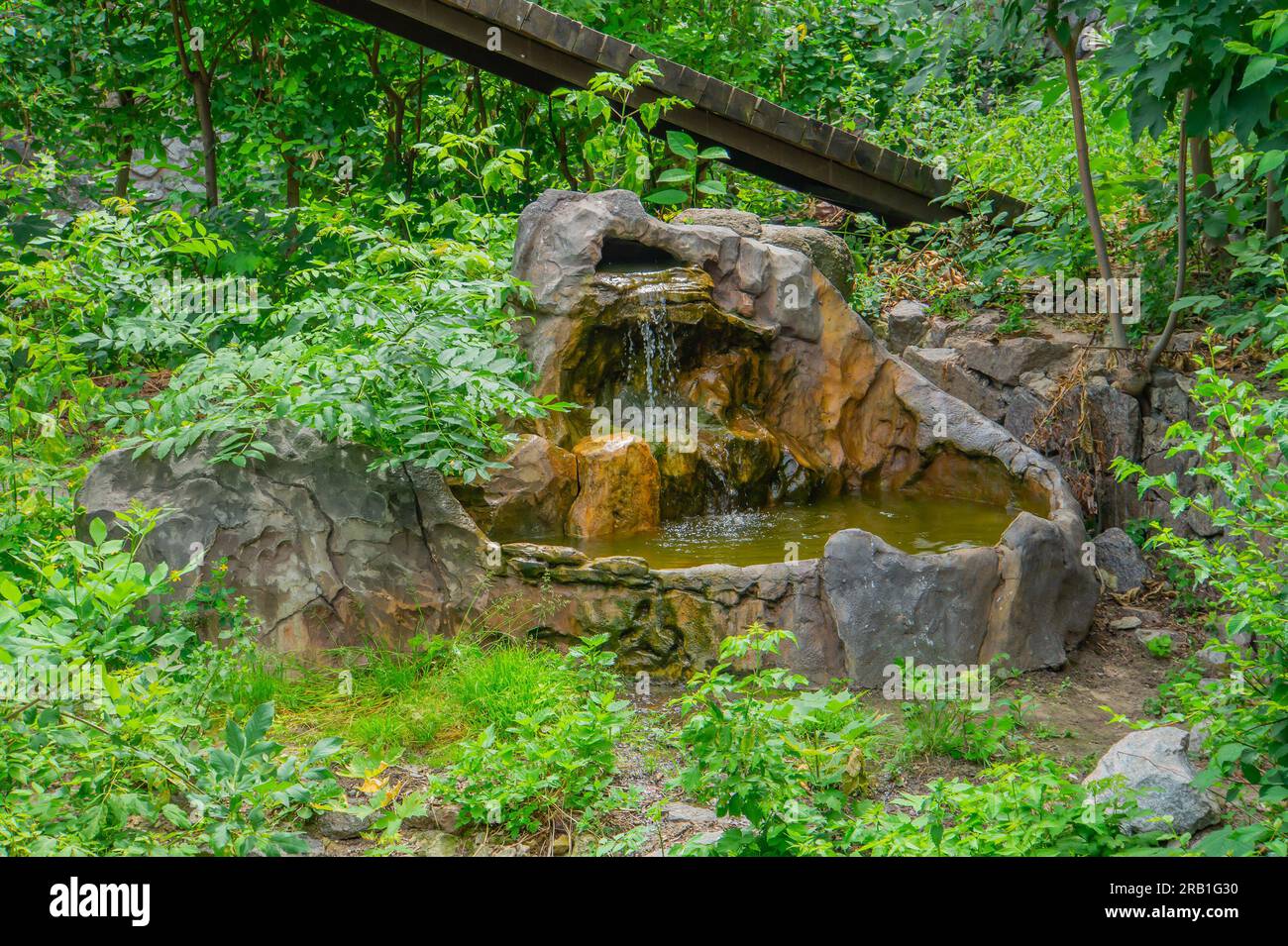 Small artificial waterfall made of granite stones. A waterfalls made of ...
