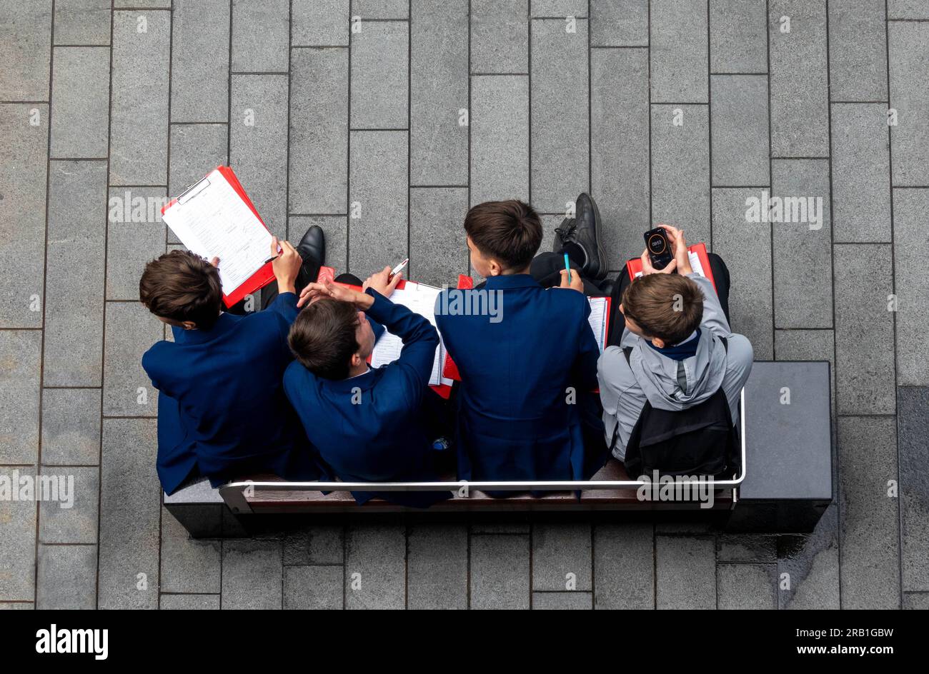 Four male middle-school students working together on a geography ...