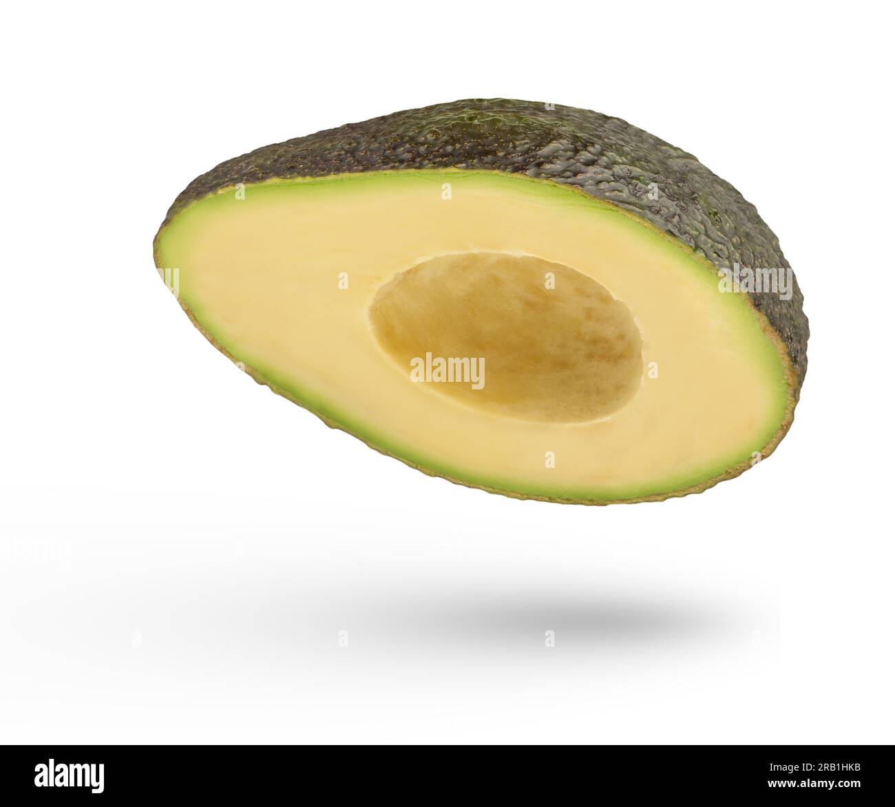 Falling fruits. Half of an avocado on a white isolated background ...