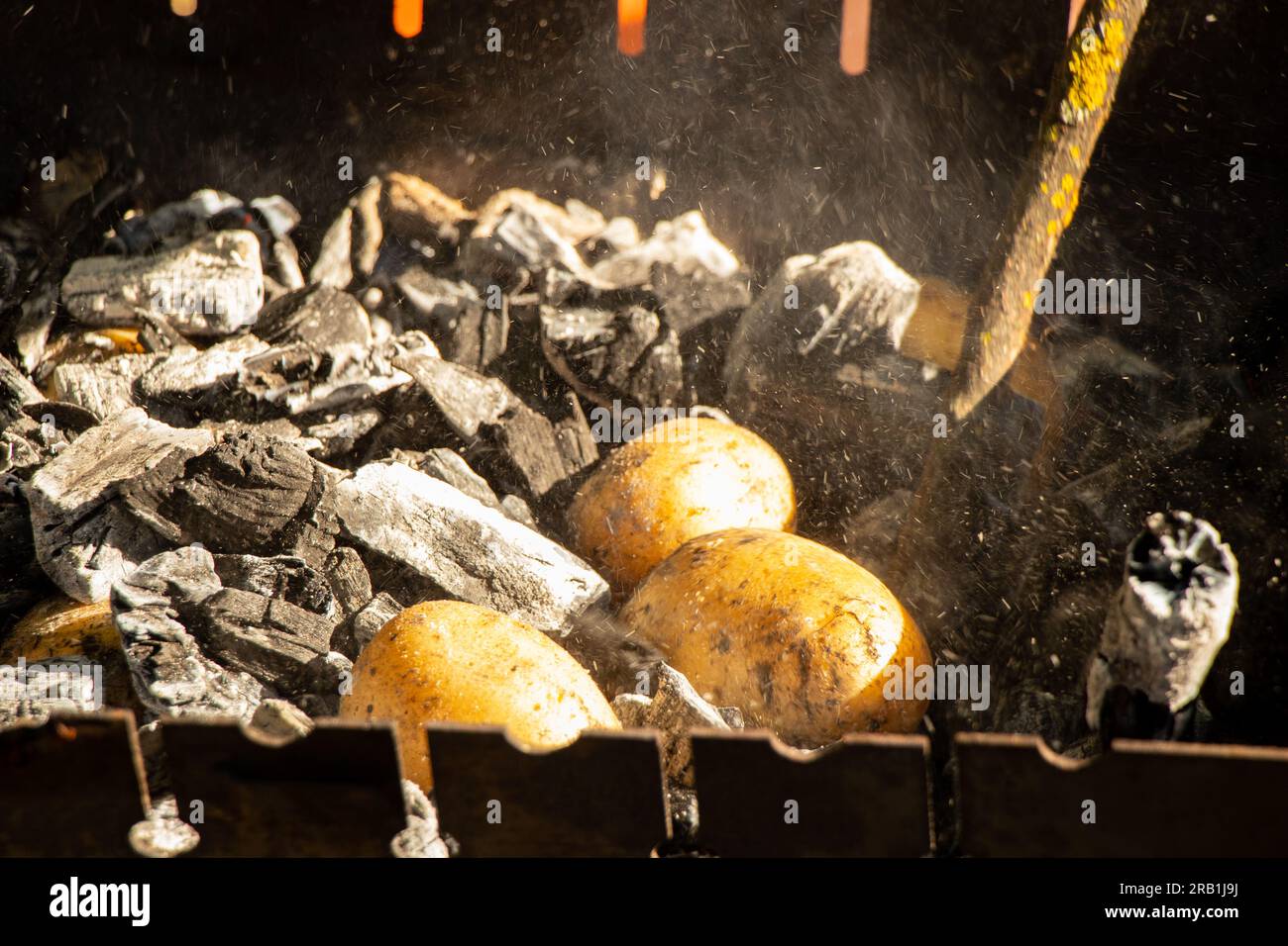 Baked potatoes on glowing embers hi-res stock photography and images ...
