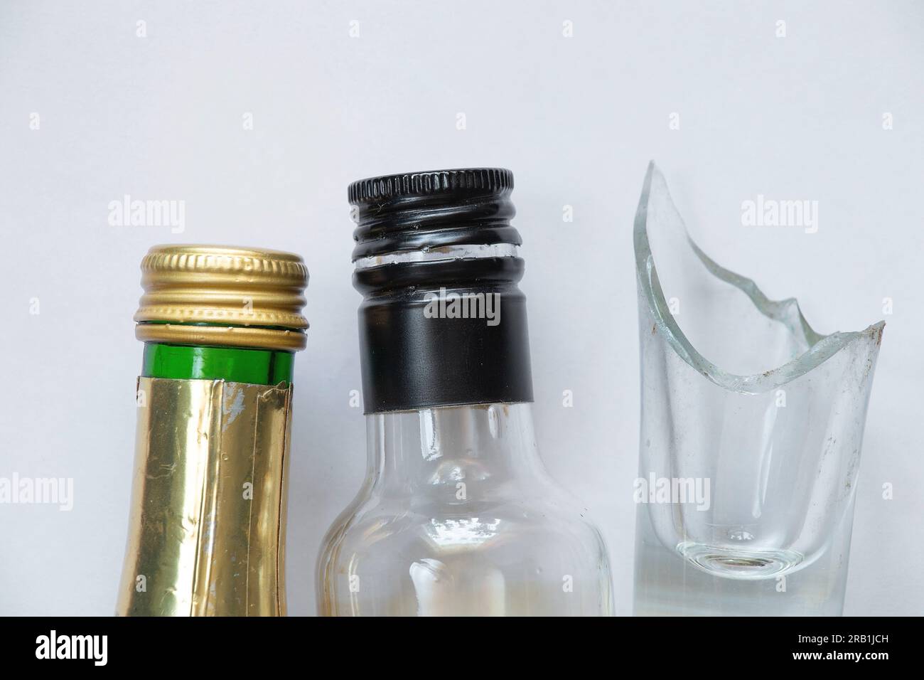 broken glass and empty bottle of alcoholic drink on white background ...