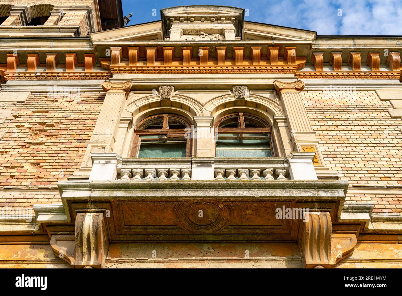 Abandoned dilapidated orange country mansion in afternoon sun with ...