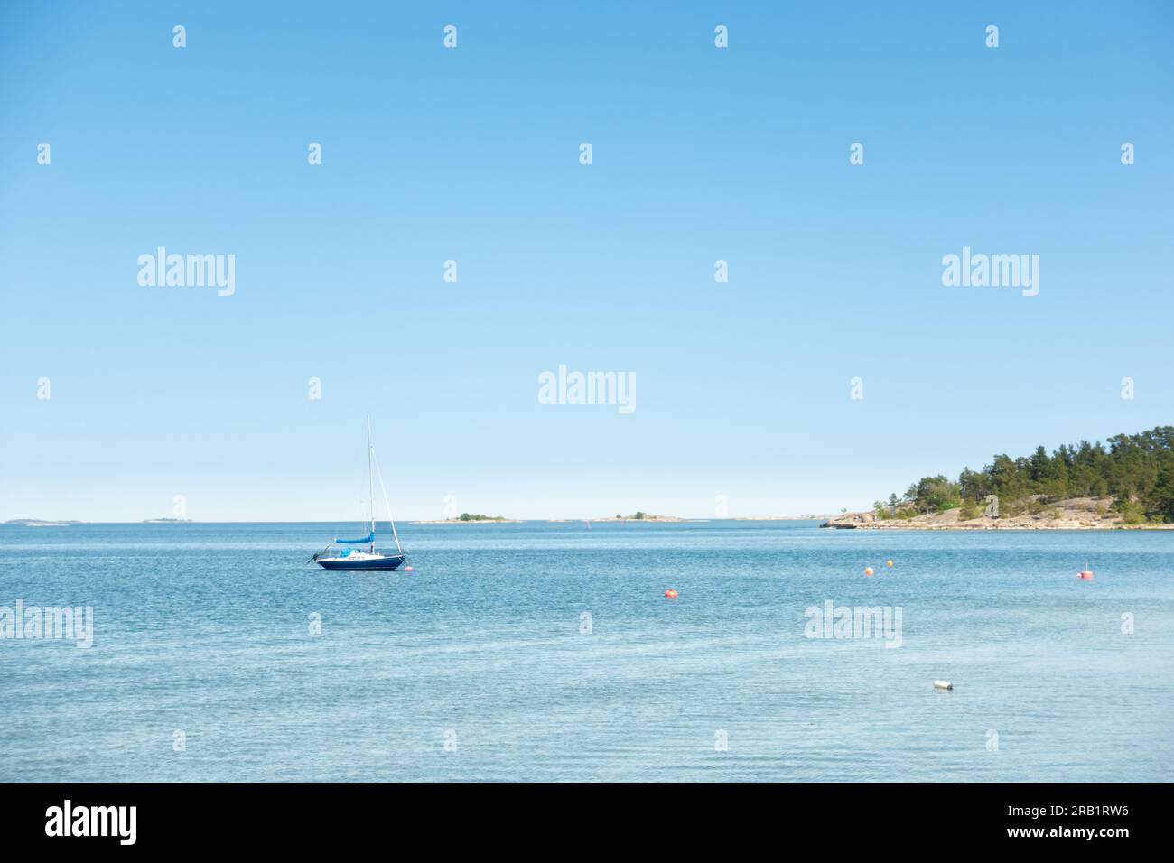 Idyllic archipelago scene with a hobbyist sailboat anchored on calm ...