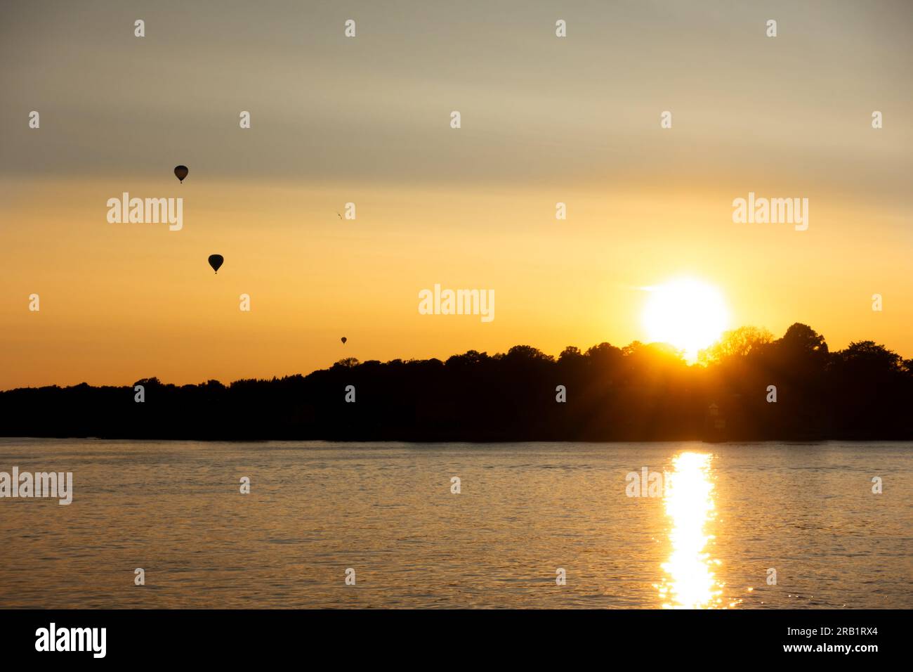 Warm orange sunset over water in Stockholm archipelago in summer with ...