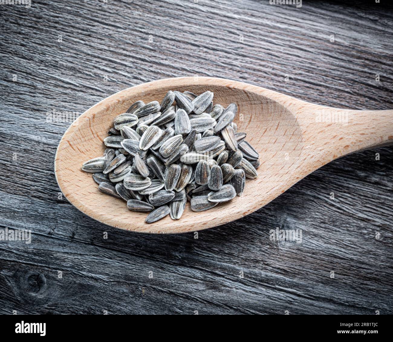 Sunflower seeds served up on a large wooden spoon, an ideal healthy ...