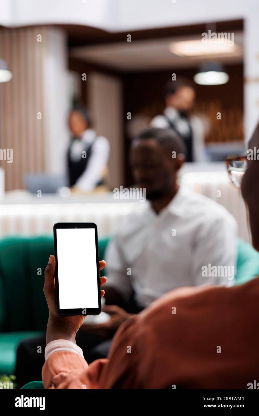 Young adult using white screen on phone, holding blank copyspace ...