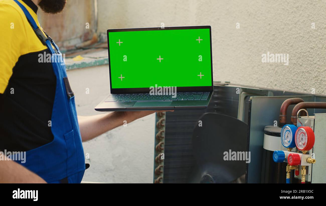 Experienced worker ordering new internal parts on green screen laptop ...