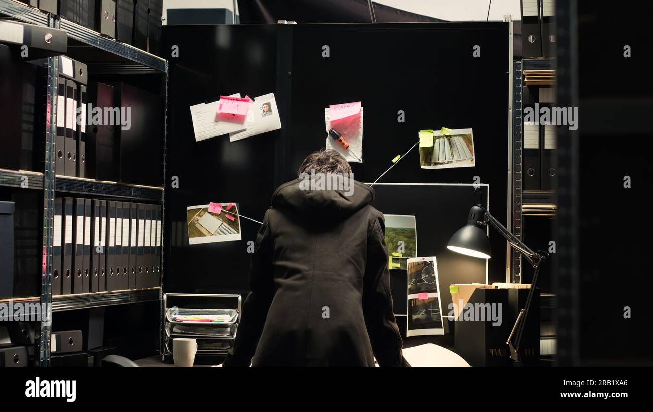 Private detective reviewing evidence files in police agency indicent ...