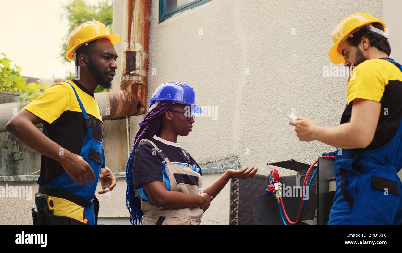 Qualified experts installing new outdoor air conditioner for home owner ...