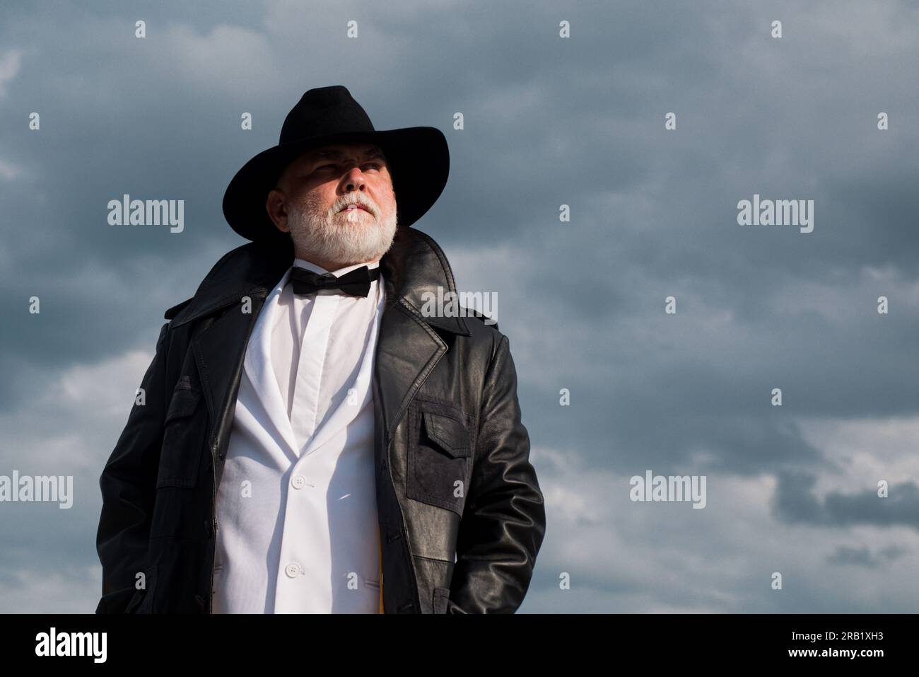 Fashion man in leather coat and hat outdoor. Cool gray bearded male ...