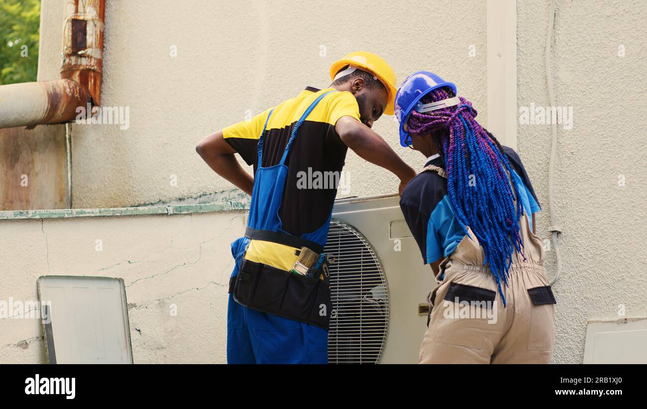 Seasoned mechanic and adept repairman opening up old broken hvac system ...