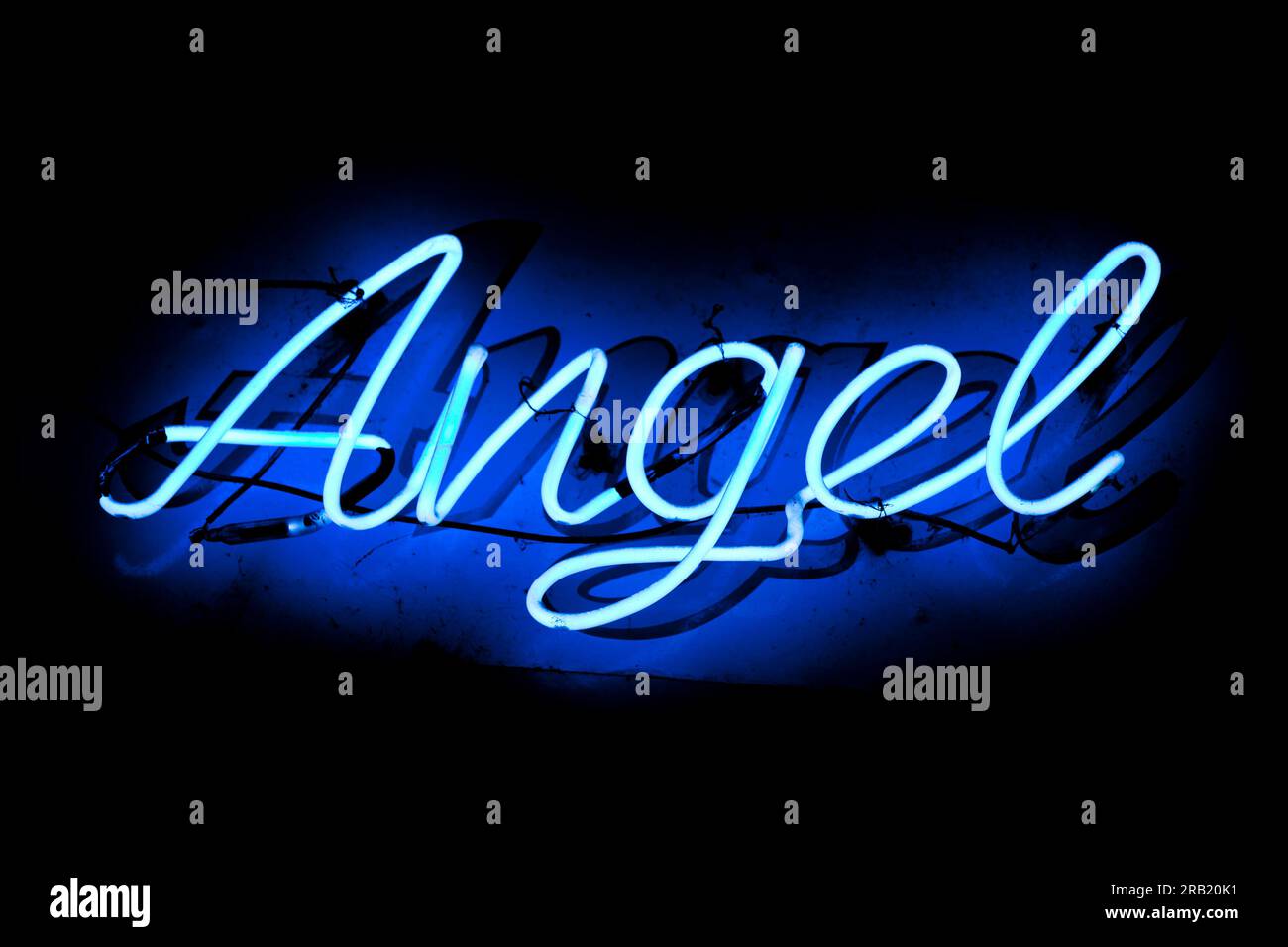 A blue neon light shaped into the word “Angel” glowing on a black ...