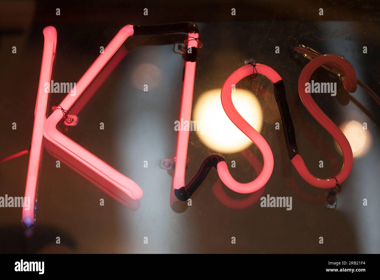 A pink neon light shaped into the word “Kiss” Stock Photo - Alamy