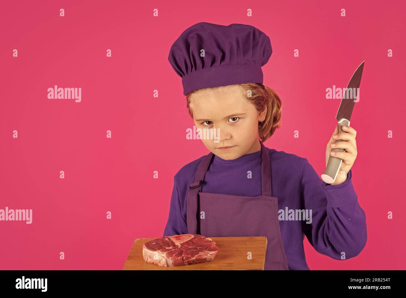 Child cook hold cutting board with meat beef steak and knife. Kid chef ...