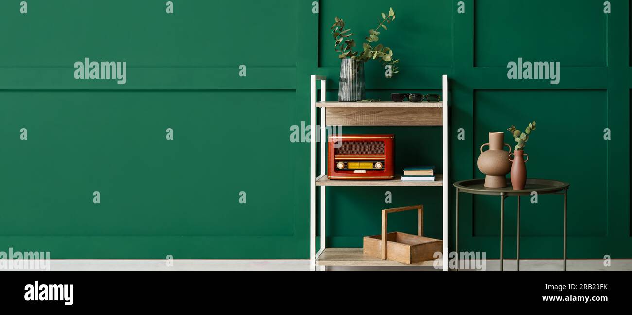 Wooden shelving unit with retro radio receiver and table with vases ...