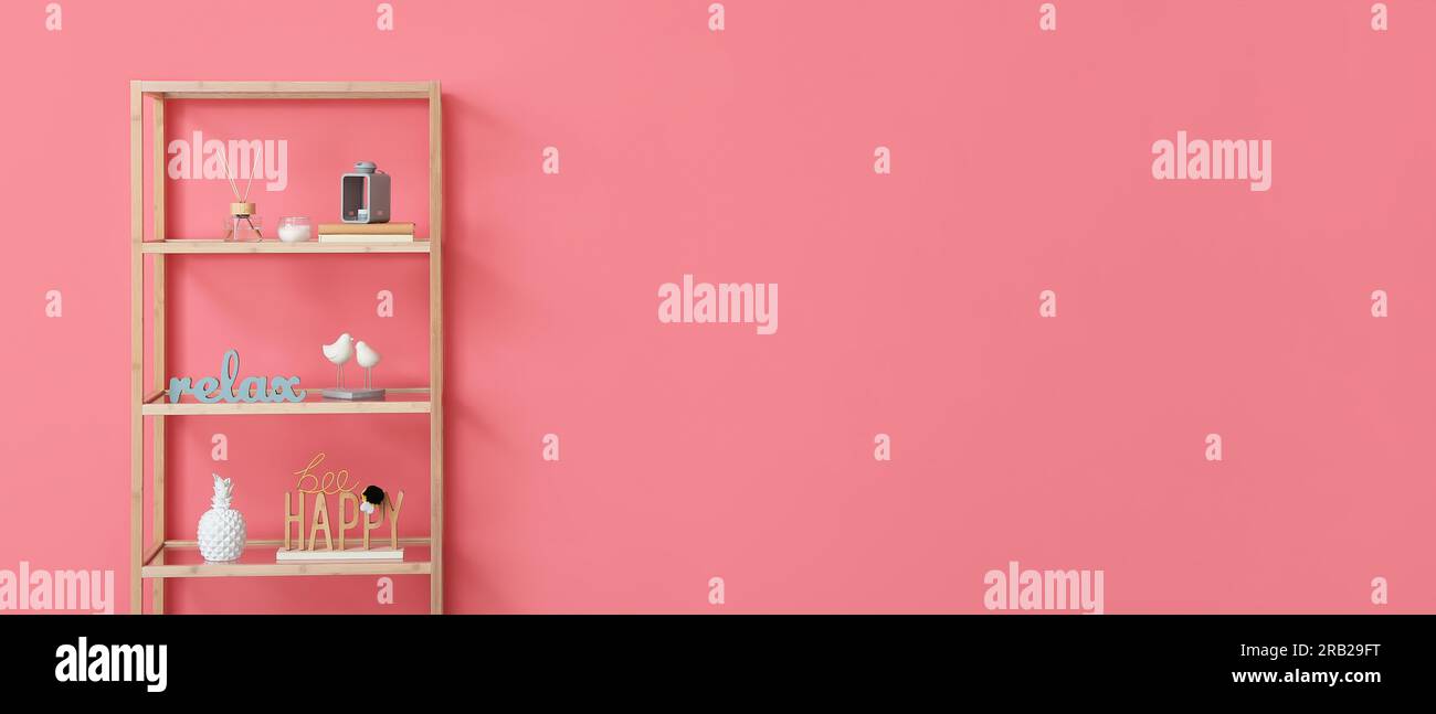 Stylish shelving unit with decor near pink wall. Banner for design ...