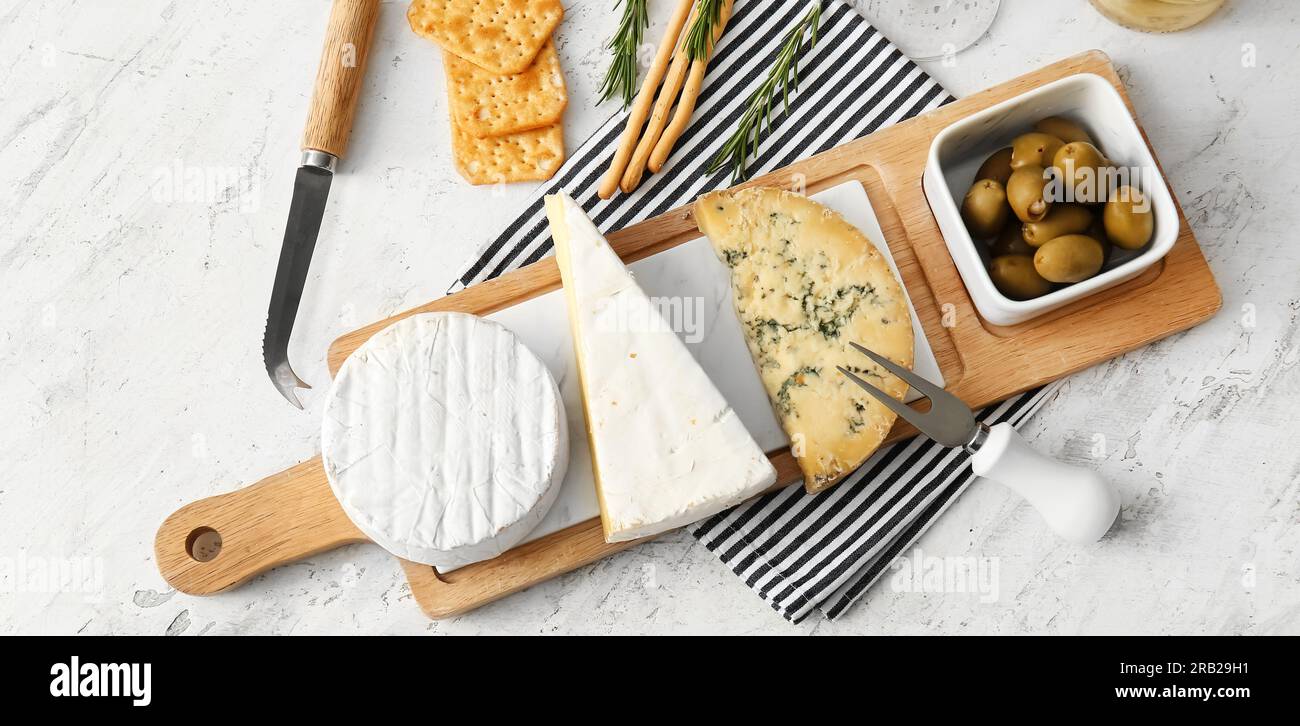 Board with tasty cheese and snacks on light background Stock Photo - Alamy