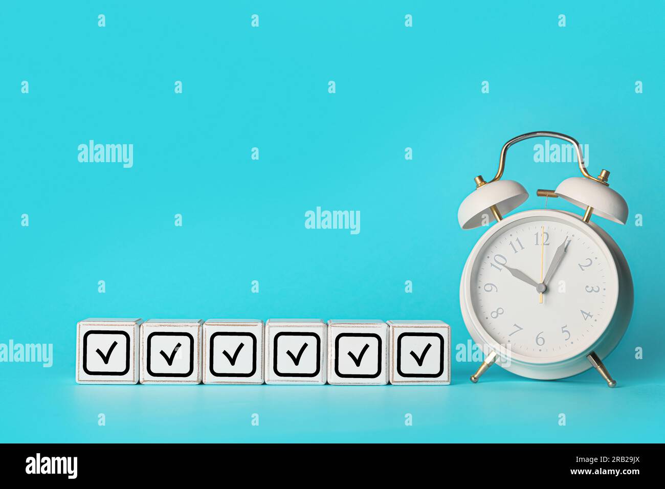 White cubes with check marks and alarm clock on light blue background ...