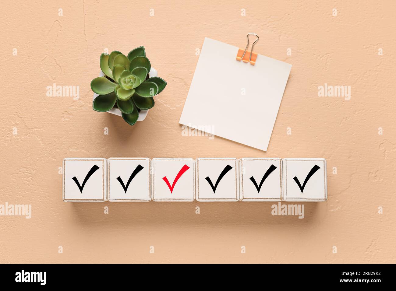 Cubes with check marks, plant and paper sheet on beige background Stock ...
