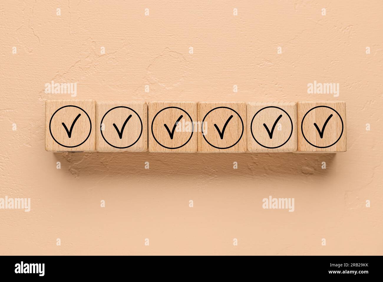 Wooden cubes with check marks on beige background Stock Photo - Alamy