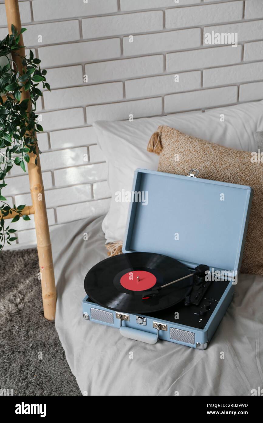 Record player with vinyl disk on bed in room Stock Photo - Alamy