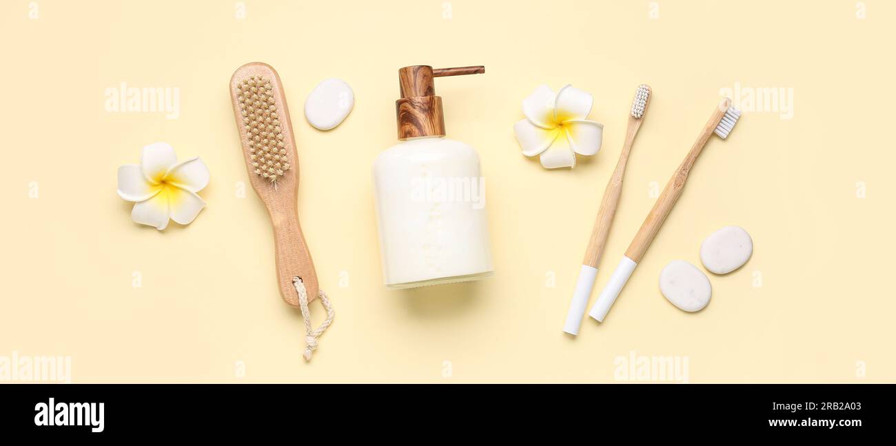 Bottle with liquid soap, spa stones, massage and tooth brushes on beige ...