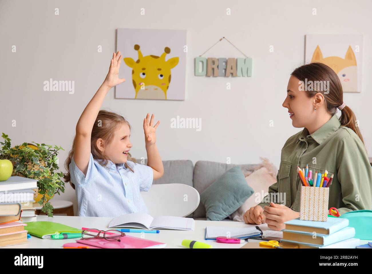 Cute little girl doing lessons with her mother at home Stock Photo - Alamy