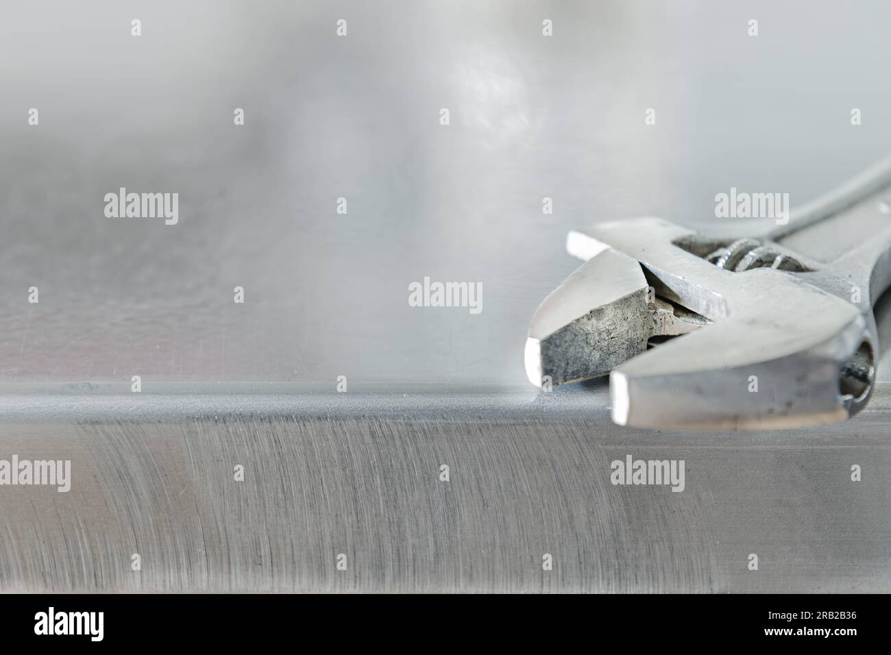 The head of a small steel spanner on a polished metal surface Stock ...