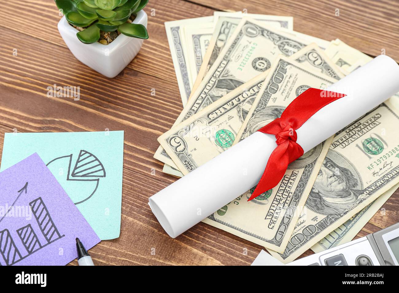 Diploma, dollar banknotes and sticky notes charts on wooden background ...
