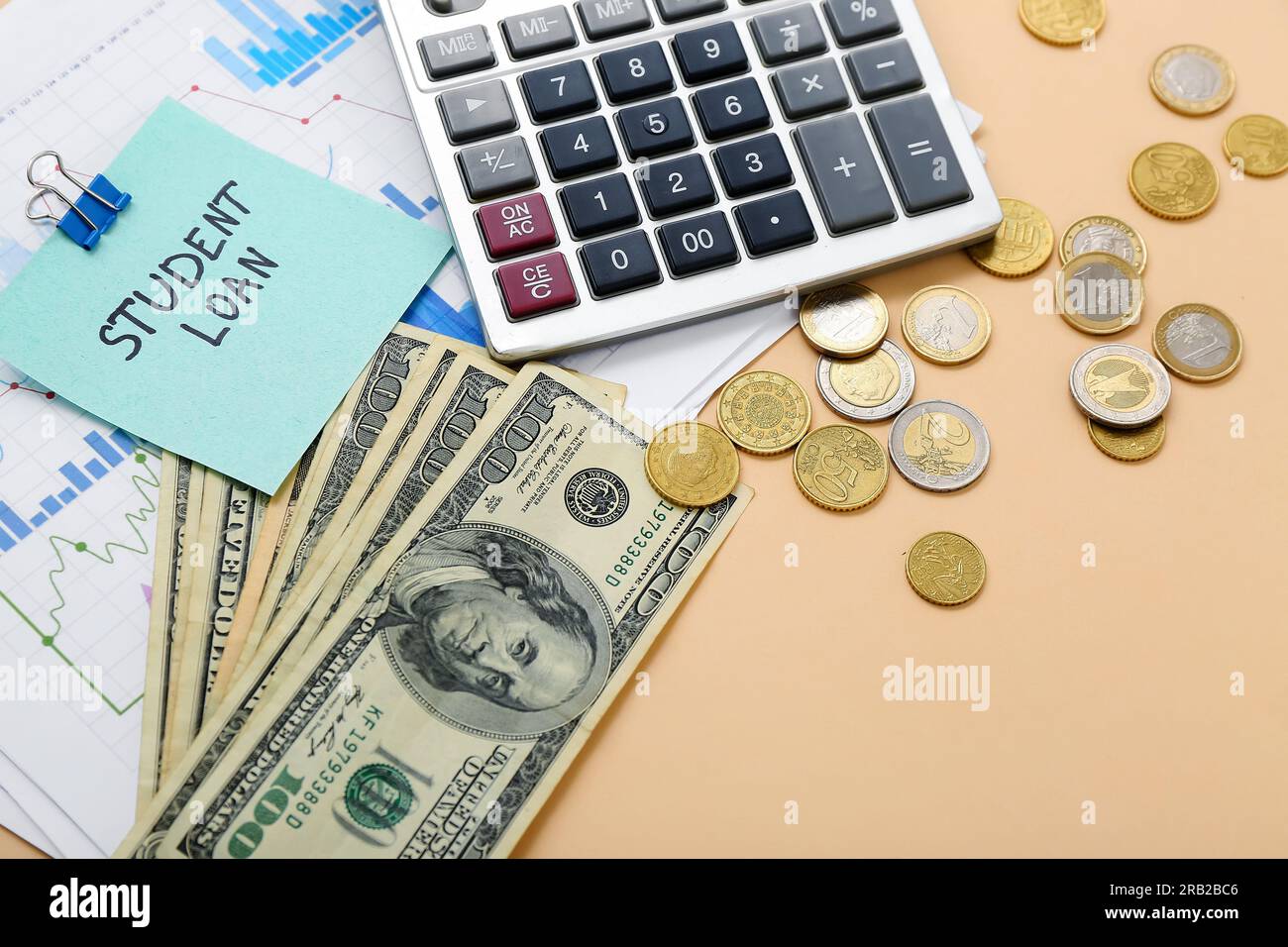 Sticky note with text STUDENT LOAN, dollar banknotes, coins, calculator ...