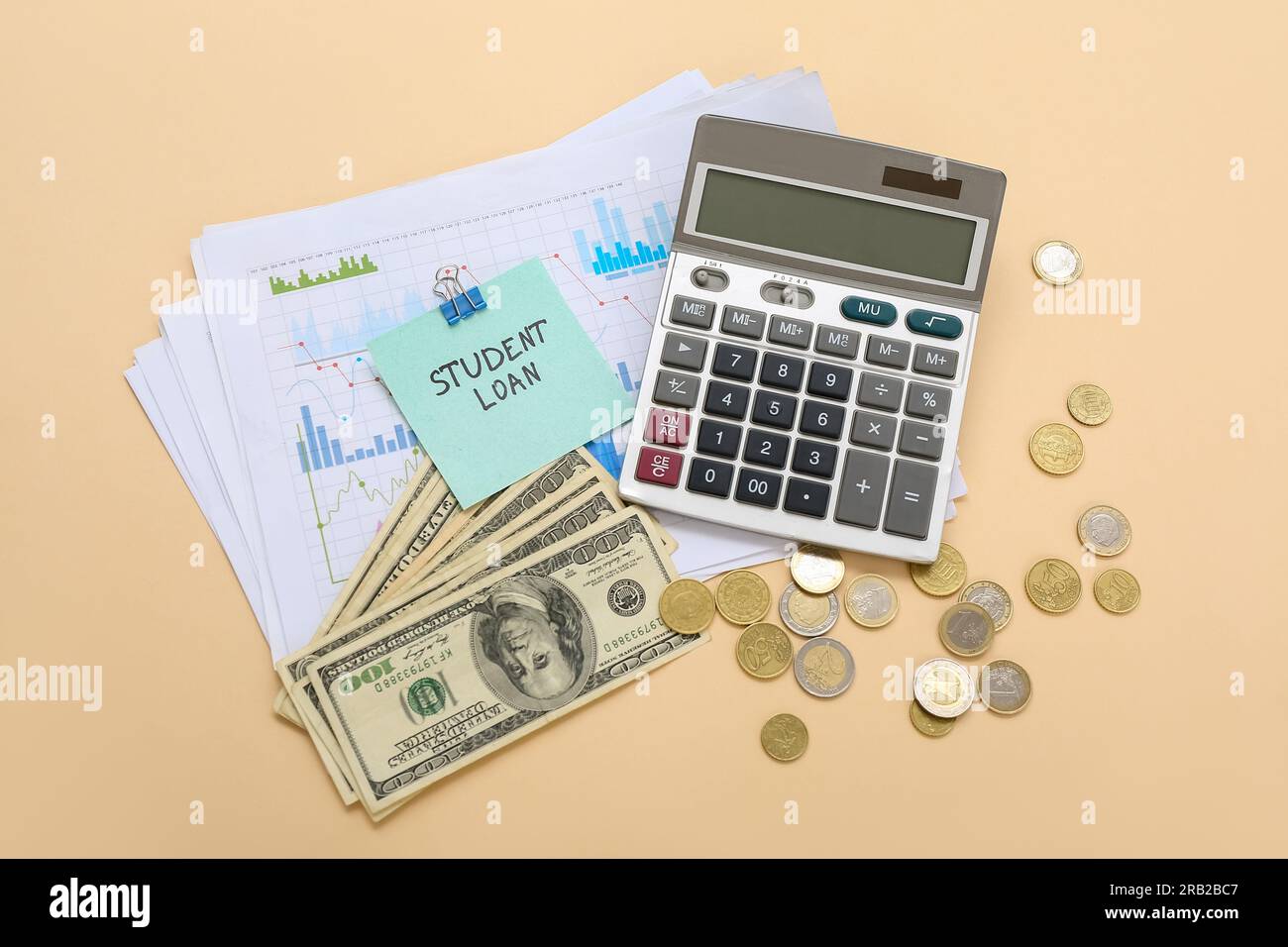 Sticky note with text STUDENT LOAN, dollar banknotes, coins, calculator ...