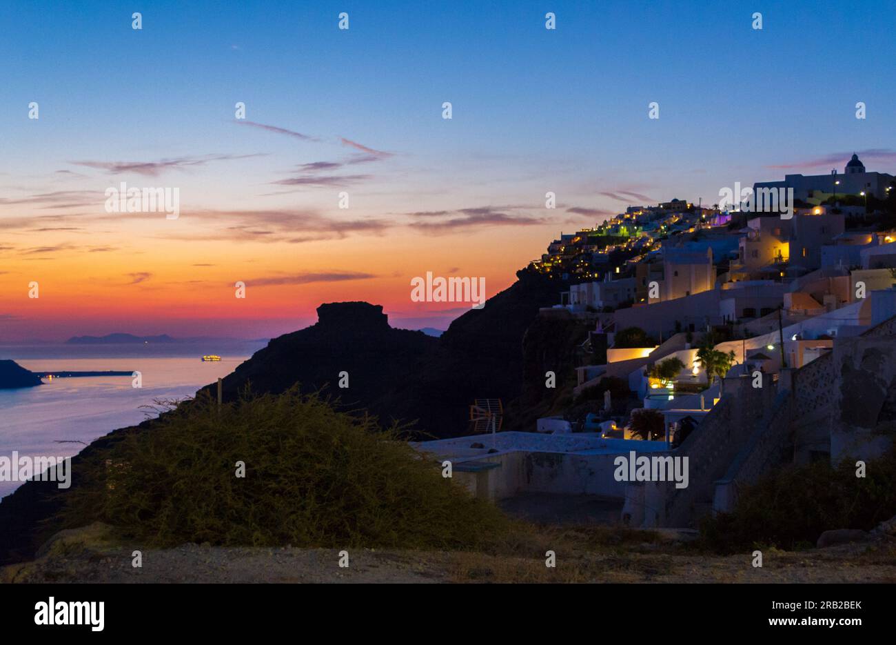 Magnificent night lights of Imerovigli on the cliff top overlooking the ...