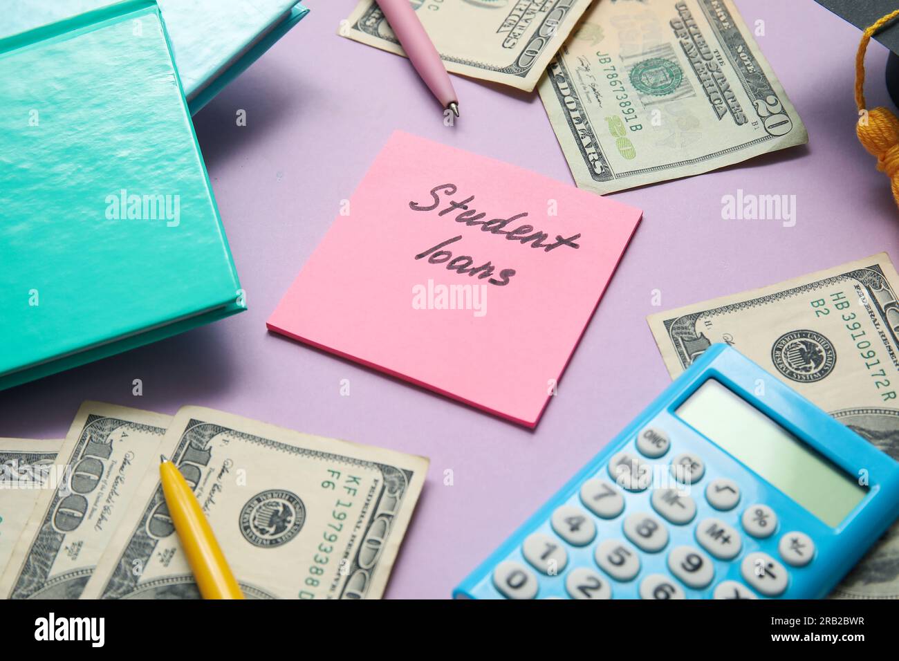 Sticky note with text STUDENT LOANS, dollar banknotes, calculator and ...